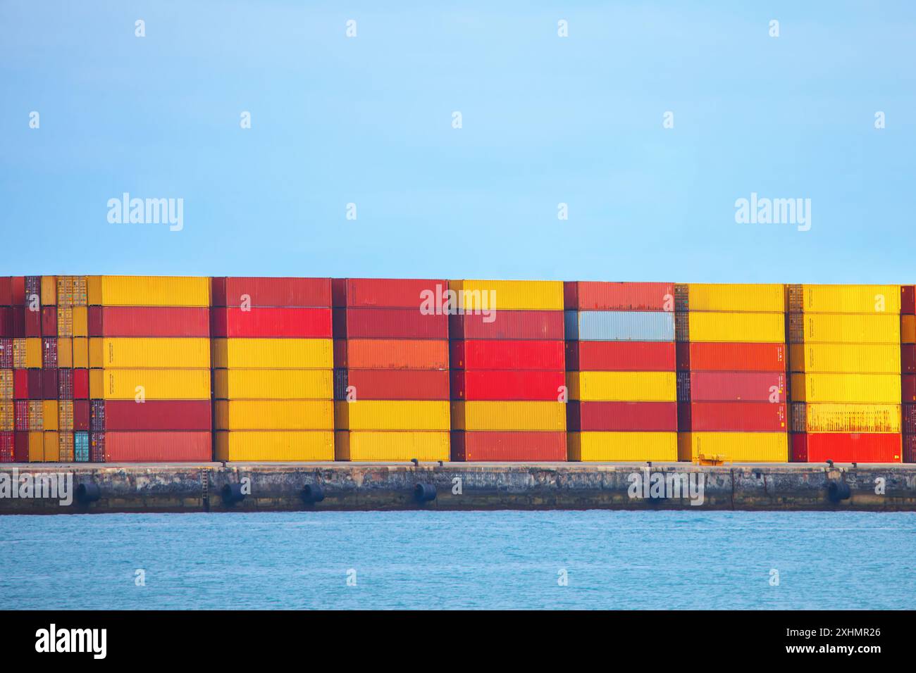 Row of yellow and red shipping containers are stacked on top of each ...