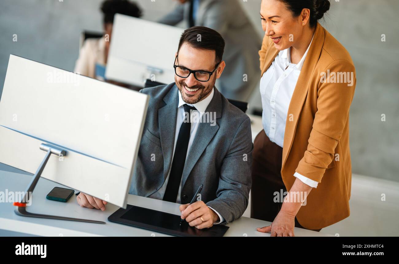 Senior business manager talking with experienced colleague while using ...