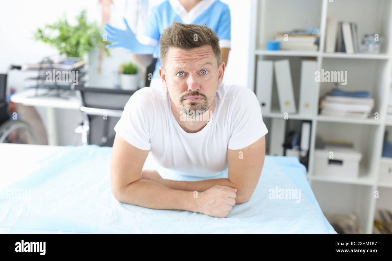 Portrait of guy at doctor appointment, nurse in manipulation room ...