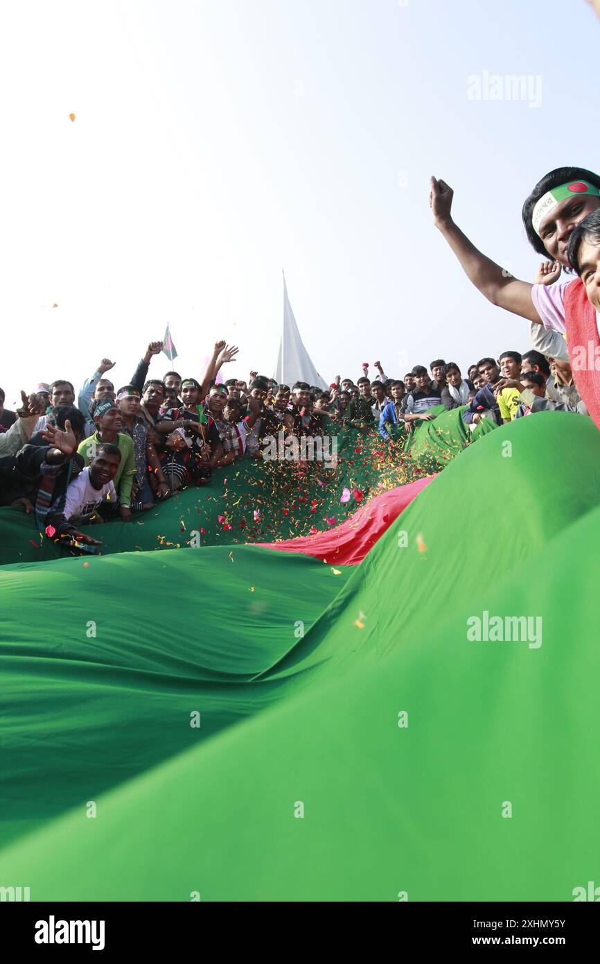 People hold on to a large national flag after paying respect to the ...