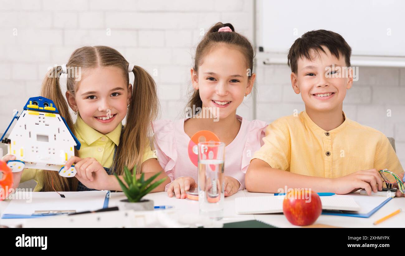Three Smiling Children Working On STEM Project In Classroom Stock Photo ...