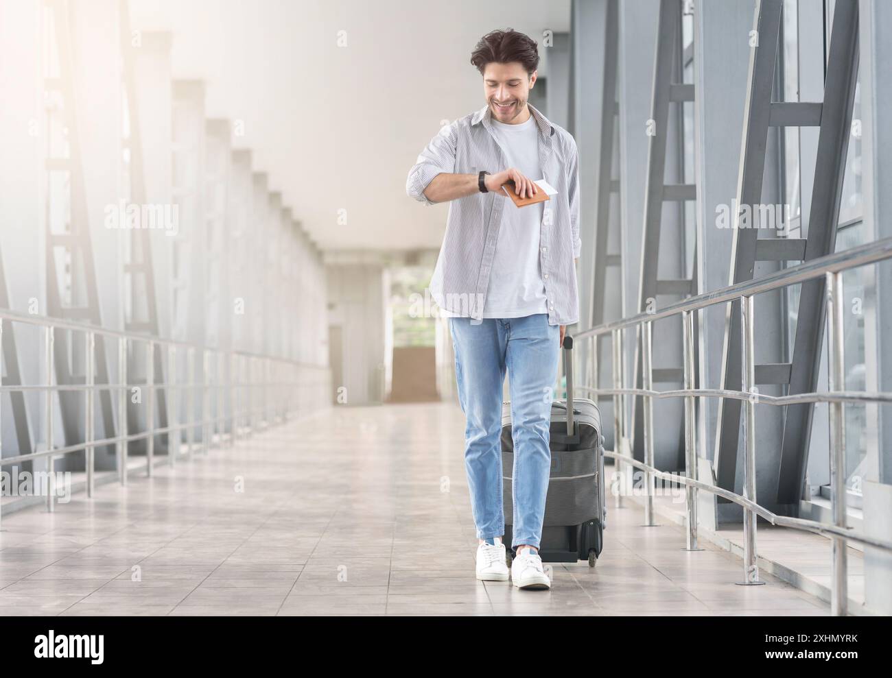 Boarding Time. Man looking at watch, walking with suitcase in airport ...
