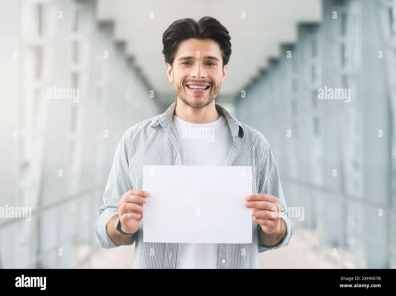 Friendly millennial man holding name board at airport Stock Photo - Alamy