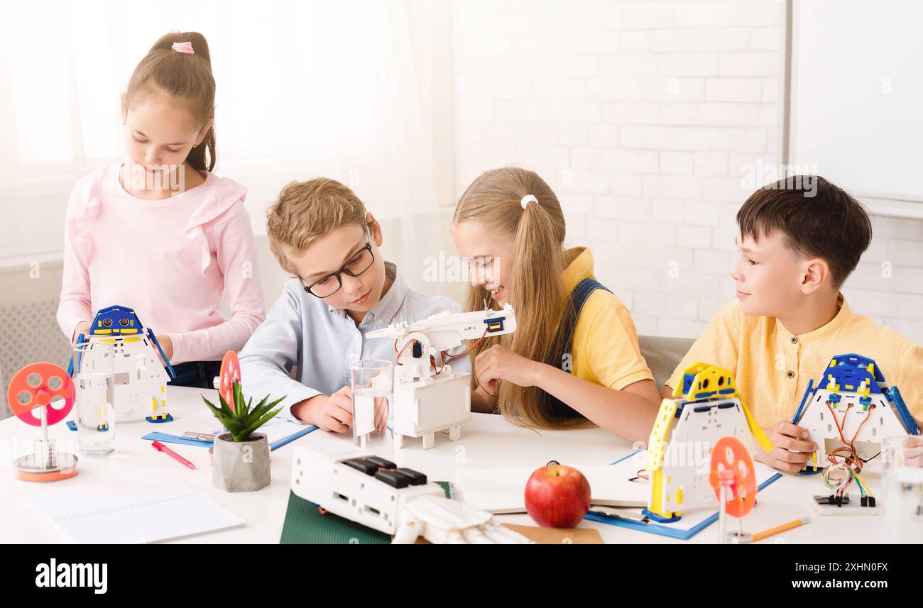 Four Young Students Building Robots In A Classroom Setting Stock Photo ...