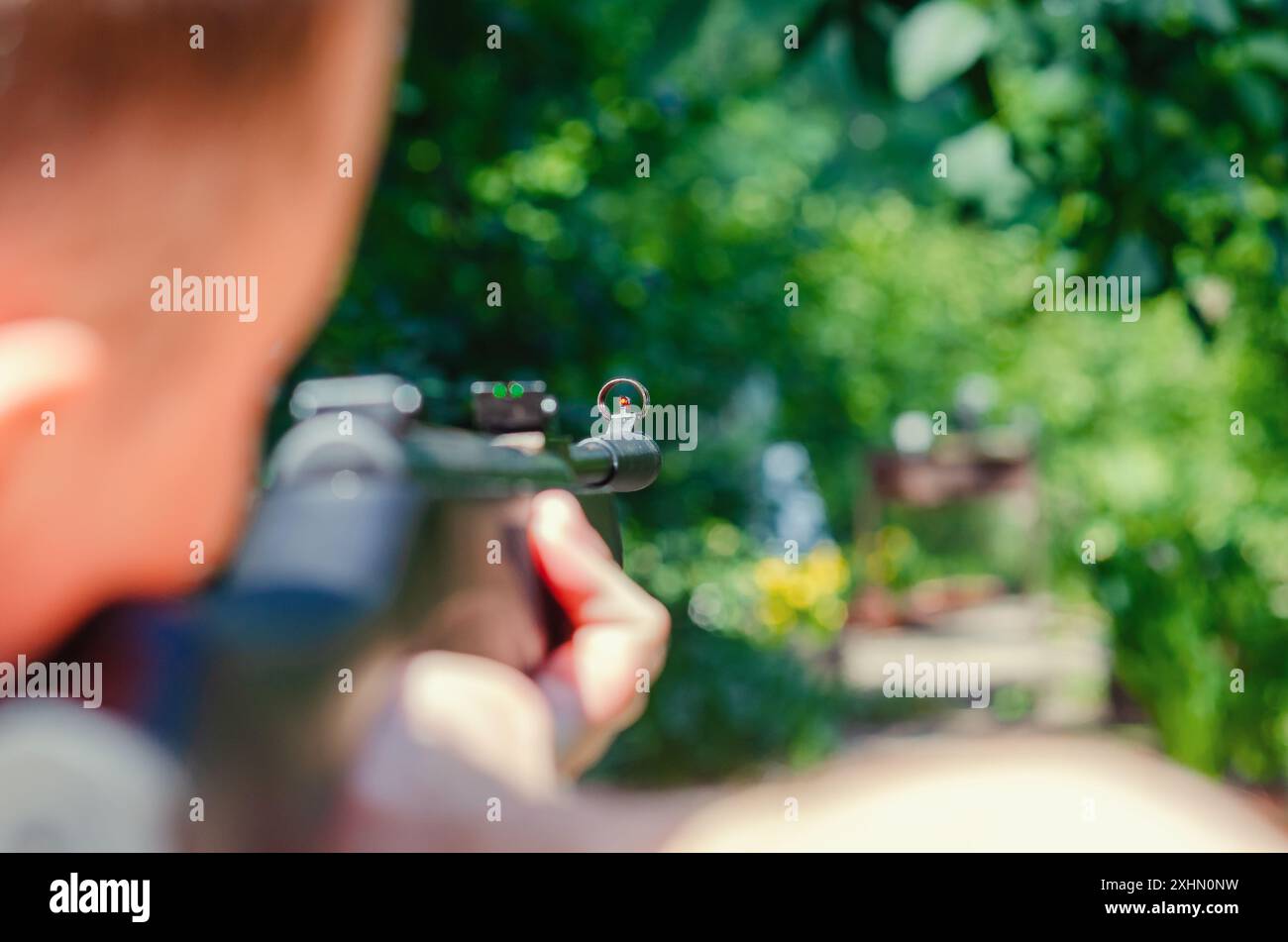 Man is holding gun and aiming. Rifle scope close-up. Selective focus ...