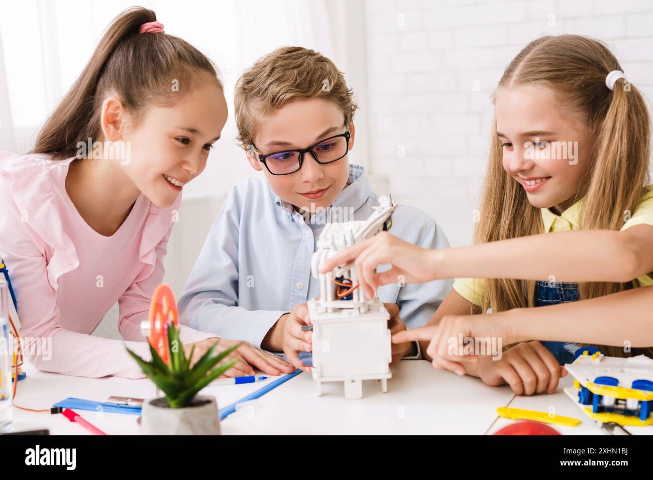 Three Children Collaborating on Robotics Project in a Classroom Setting Stock Photo - Alamy