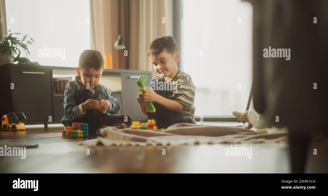 Portrait of Two Male Asian Kids Playing with Colorful Building Blocks in Their Room During the ...