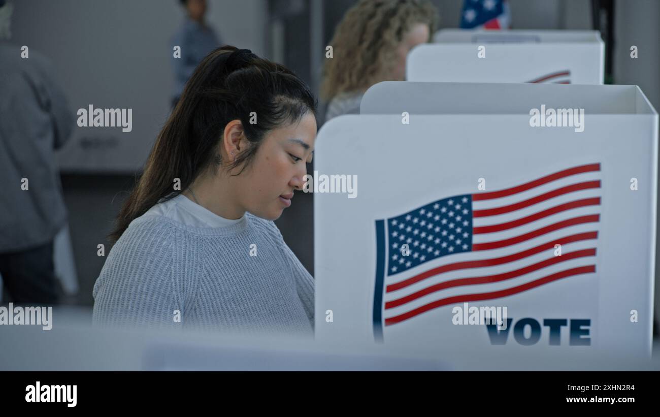 Multicultural American citizens come to voting booth in polling station ...