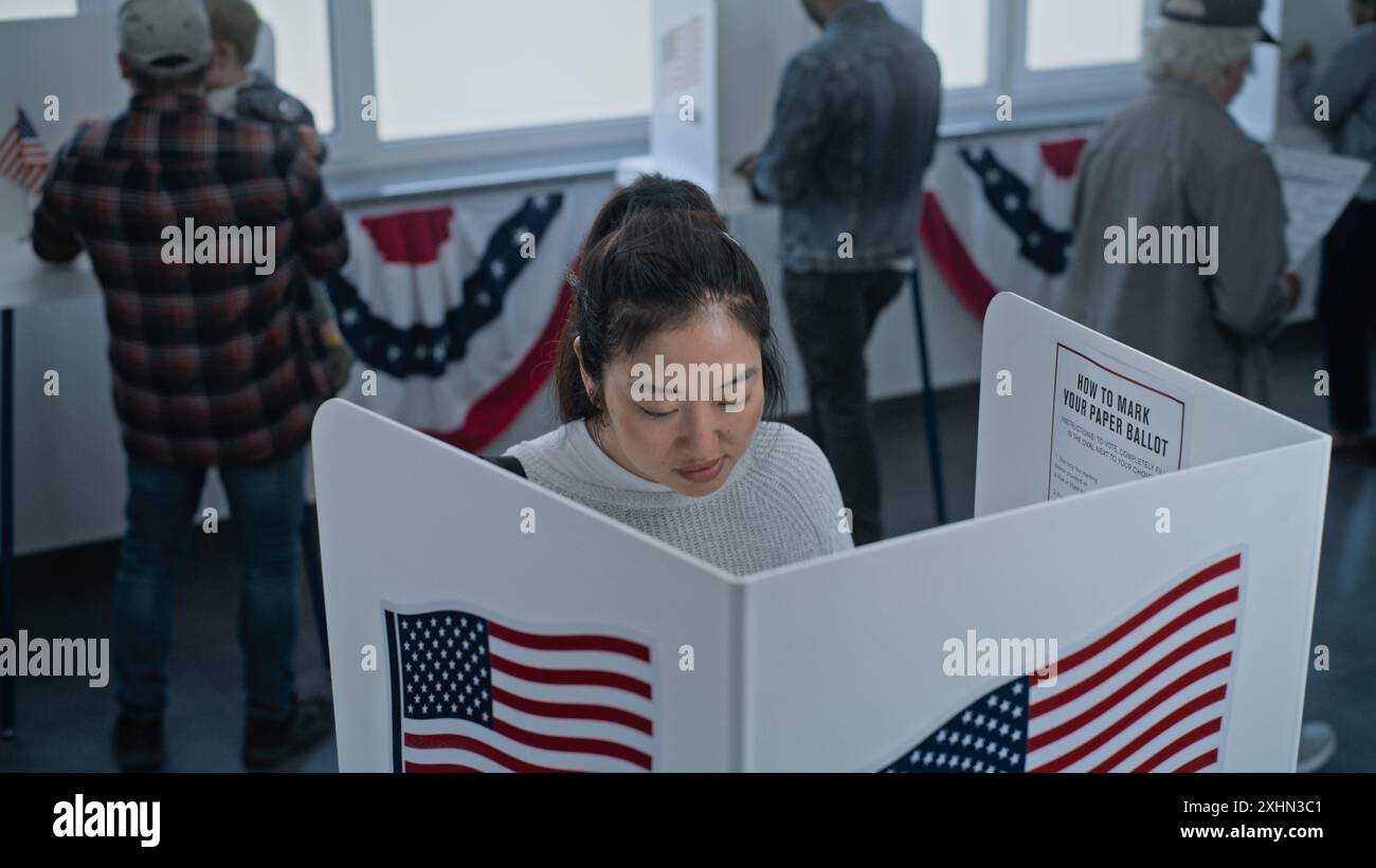 Asian woman comes to vote in booth in polling station office. National ...