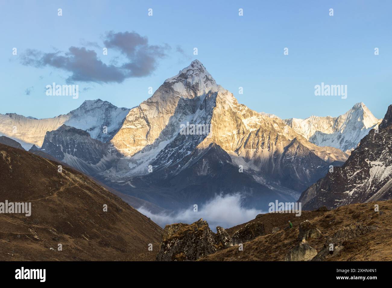 Ama Dablam mountain at sunset and blue sky. Sun illuminates slopes ...