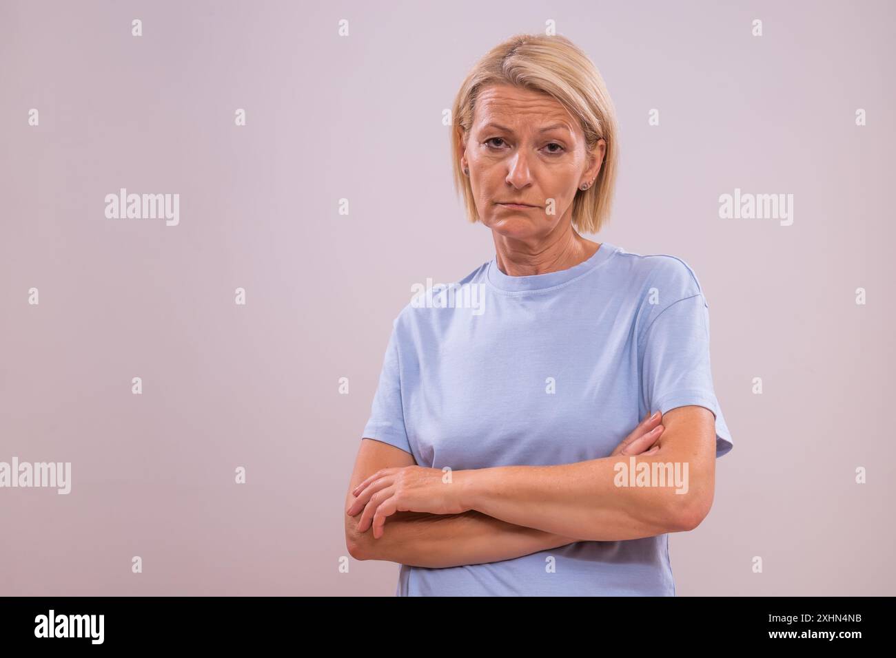 Portrait of angry mature woman thinking on a gray background Stock ...