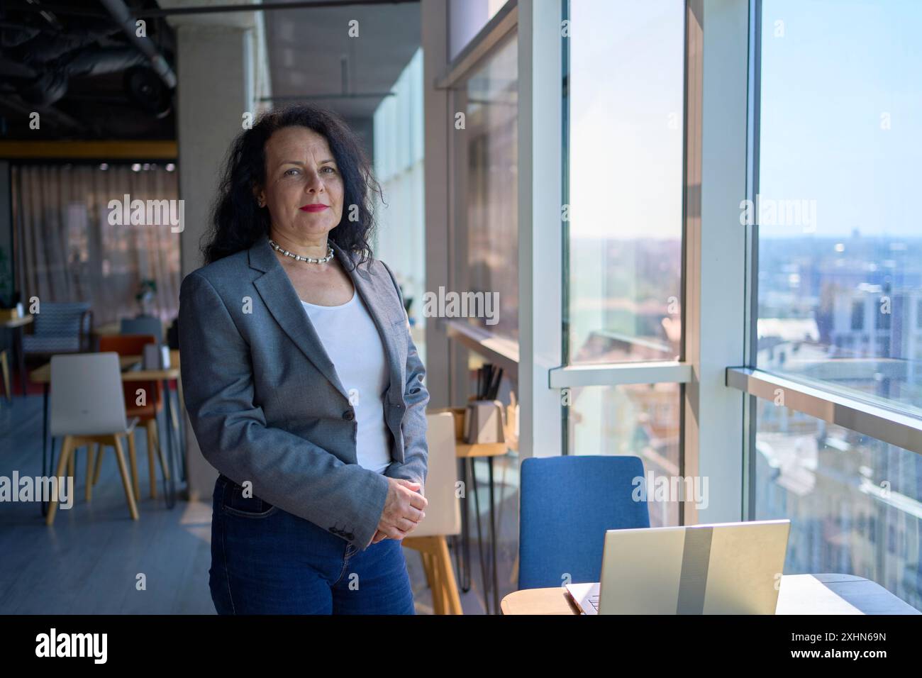 57-year-old woman works on a laptop in a modern office workspace Stock ...