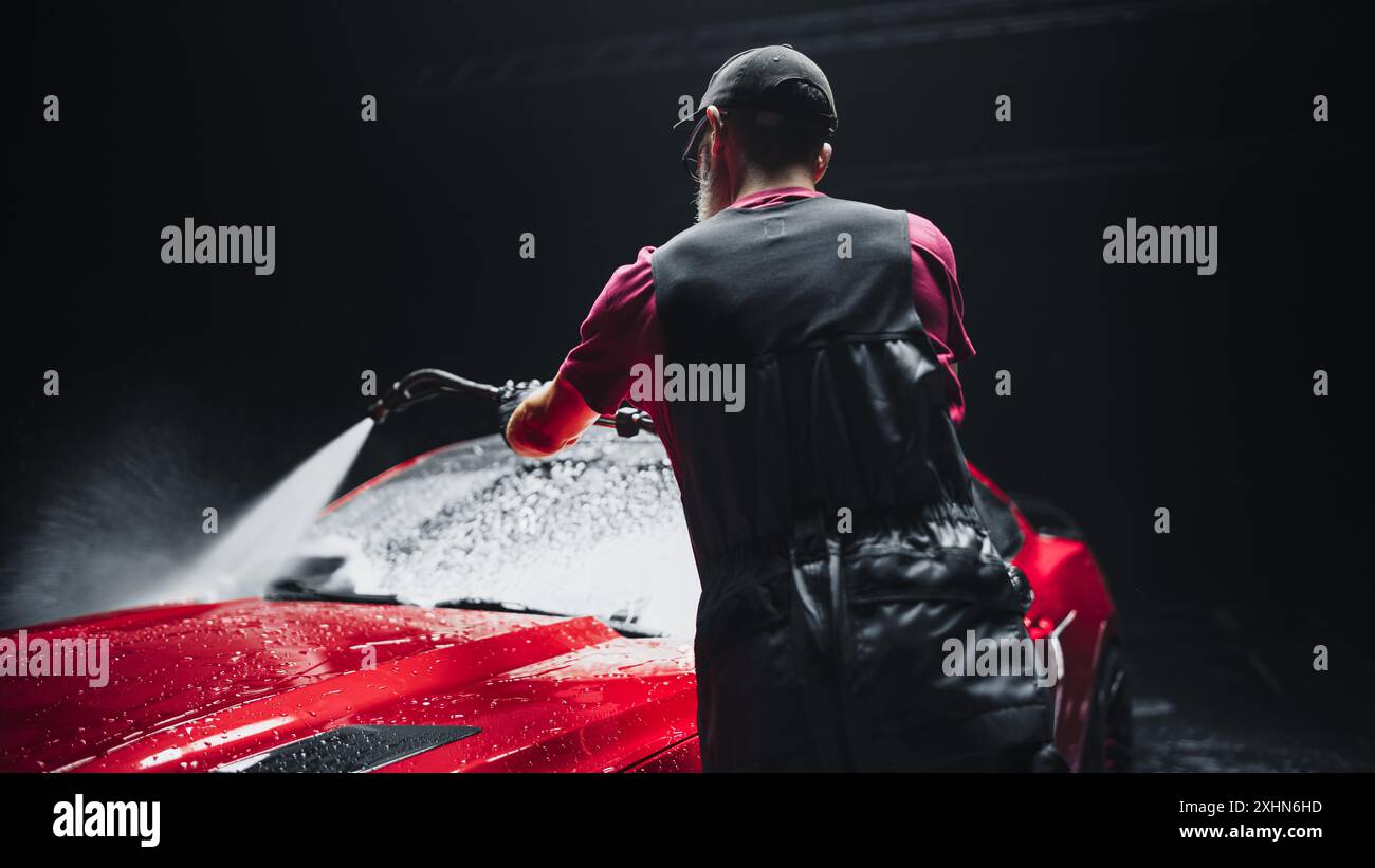 Automotive Detailer Washing Away Shampoo from the Windshield with a ...