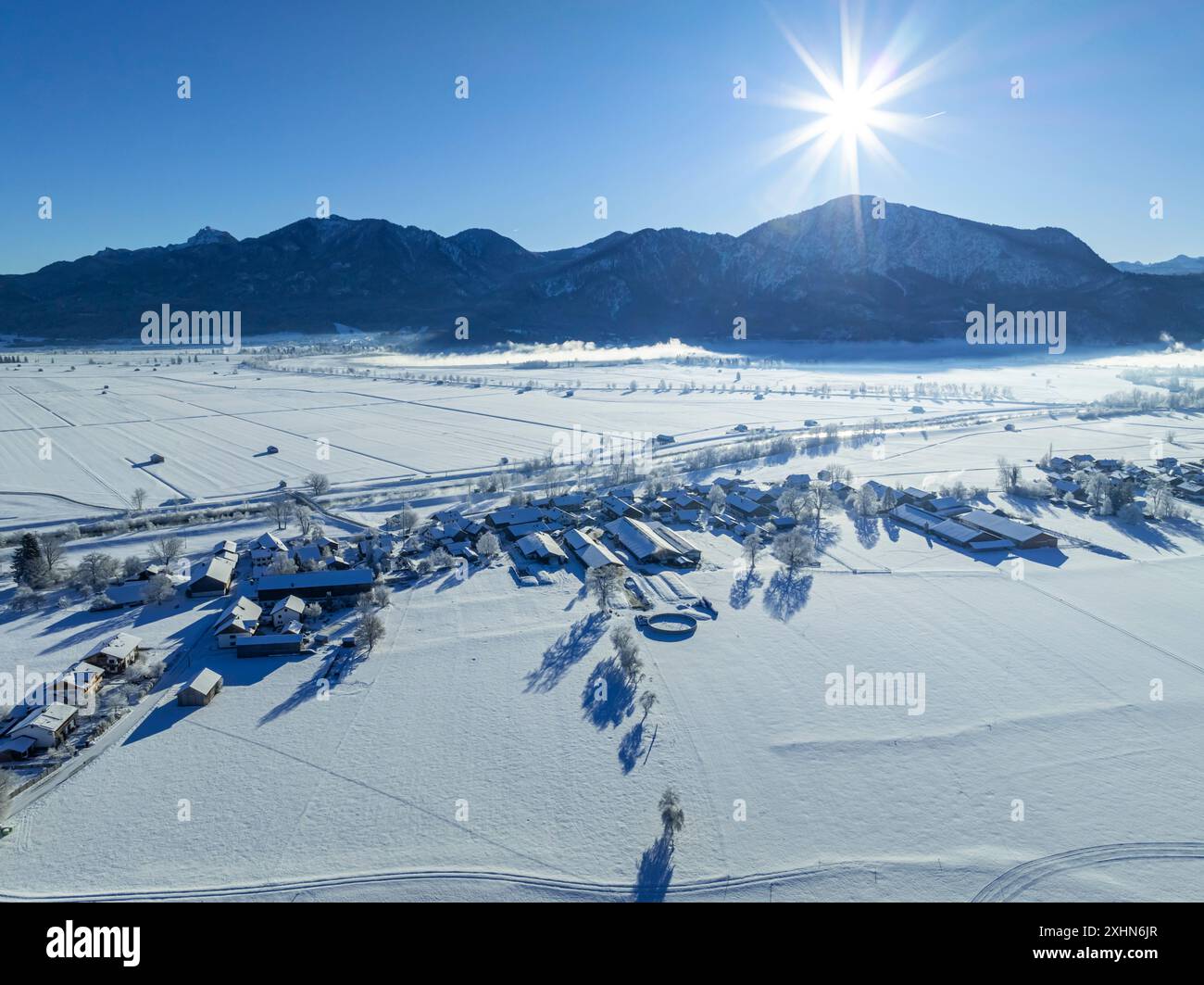 Aerial view of a village in front of mountains, sunny, winter, View to ...