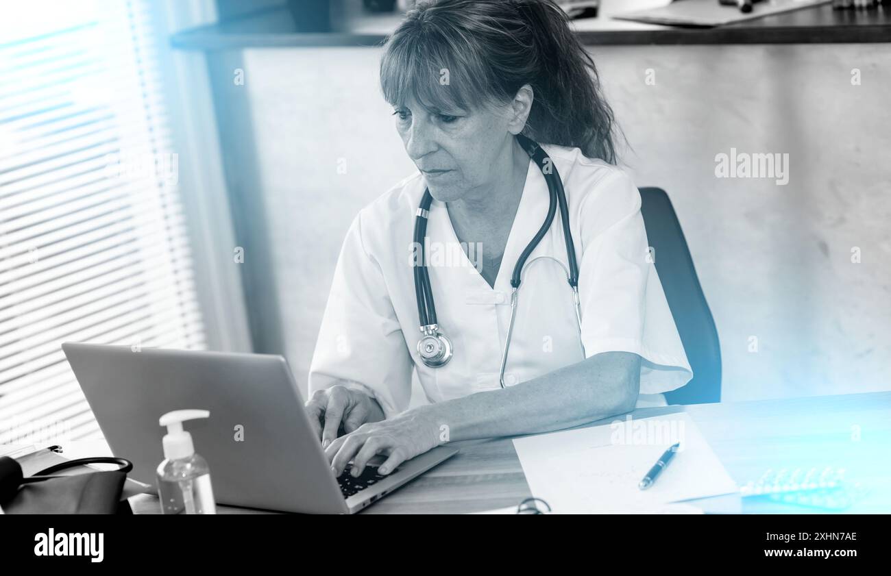 Female doctor using laptop in medical office; light effect Stock Photo ...