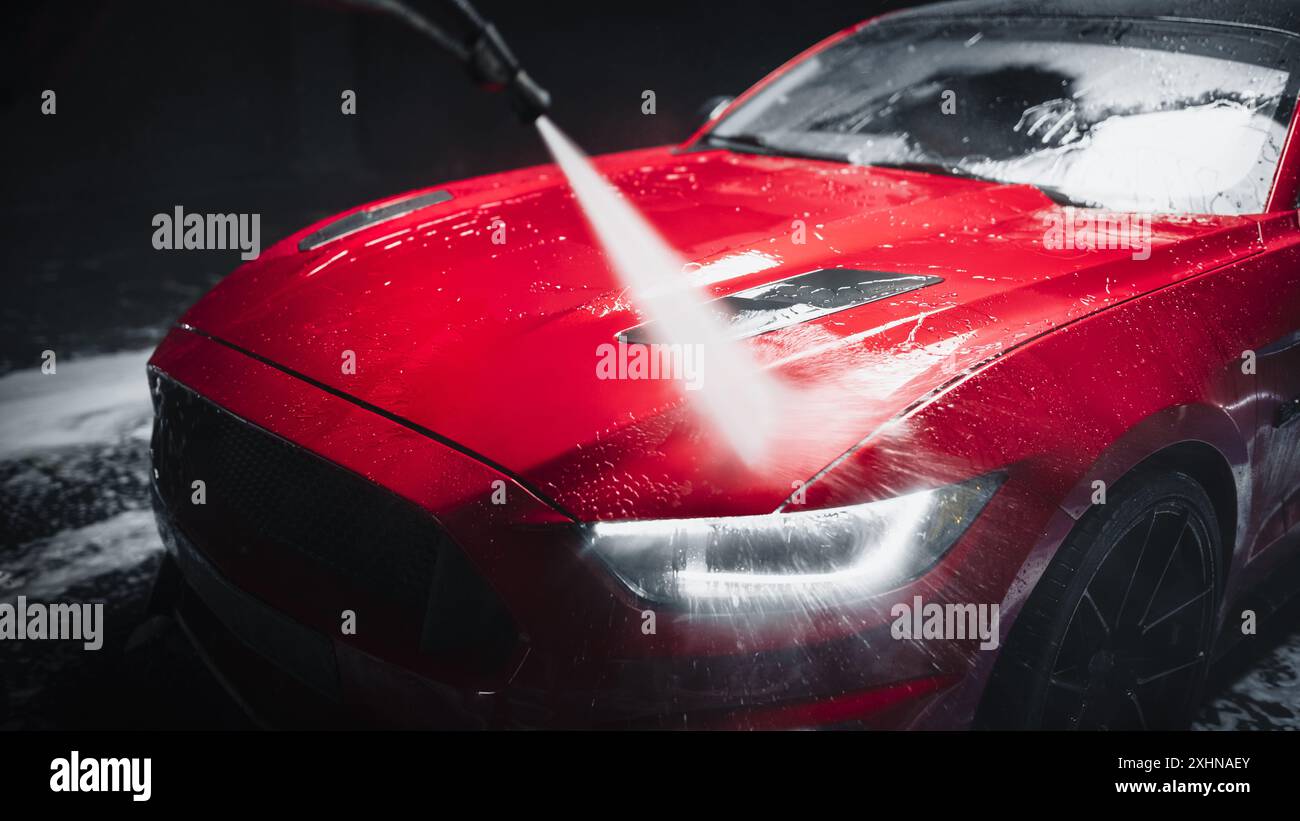 Car Wash Expert Using Water Pressure Washer to Rinse a Red Modern ...