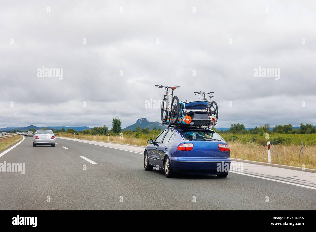Back view modern white family wagon car with mounted roof box trunk and ...