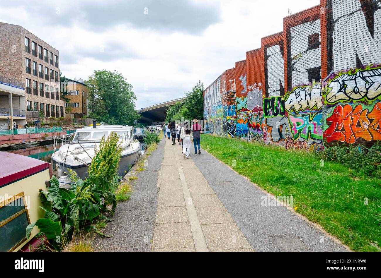 People walk along the tow path alongside The Grand Union Canal ...