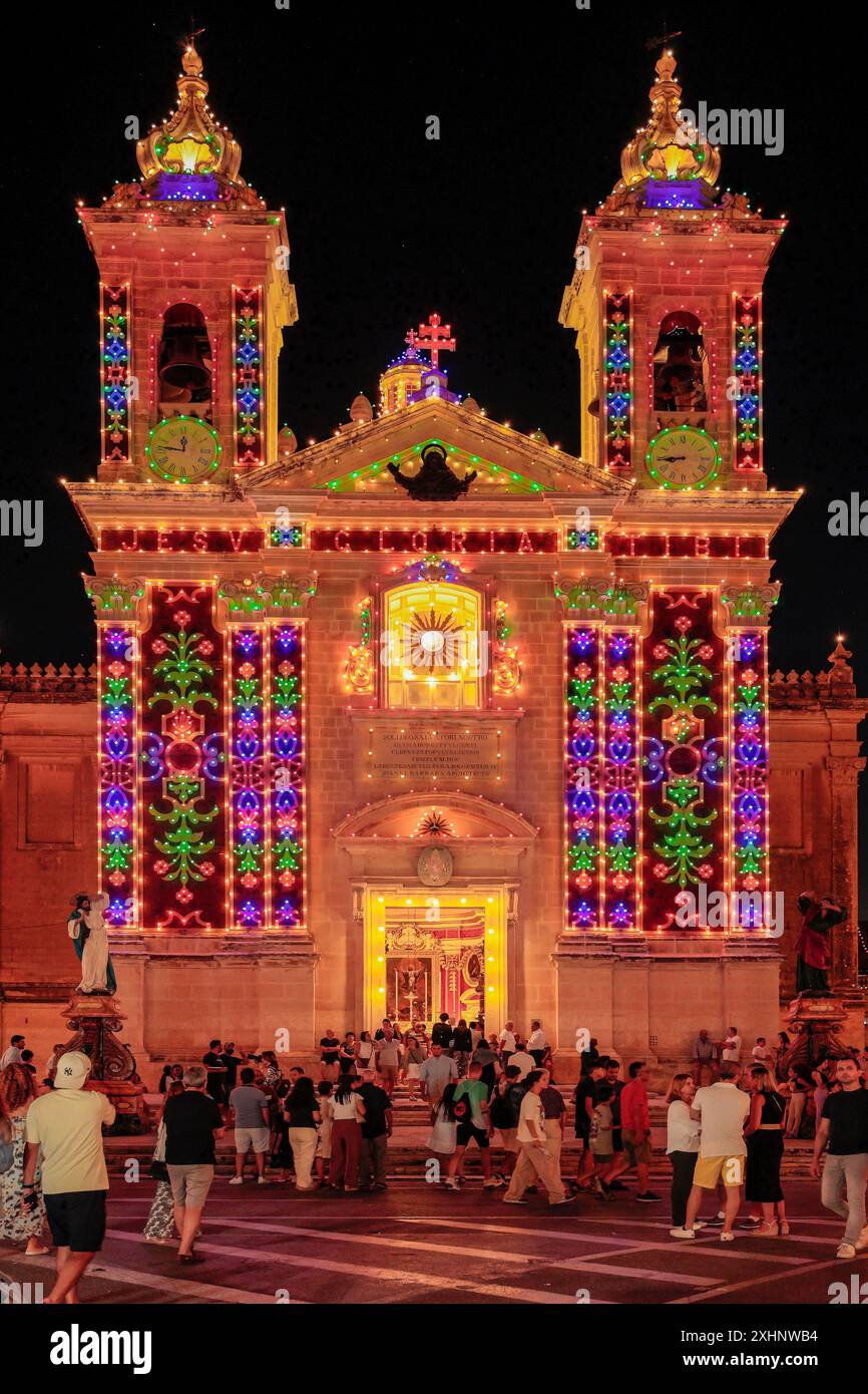 The facade of the parish church of Lija illuminated with multi coloured lights on the titular ...