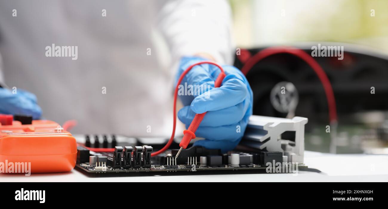 Technician measuring voltage of in computer mainboard using electronic ...
