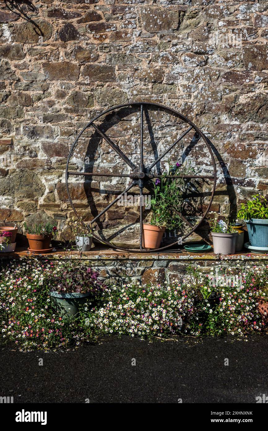 An old metal wheel decorates an old house in the country Stock Photo ...