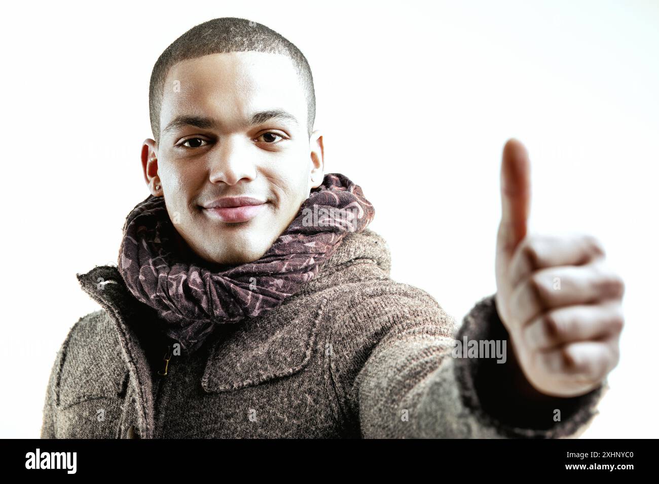 Man (in focus) in a grey coat and blue scarf, smiling warmly and giving ...