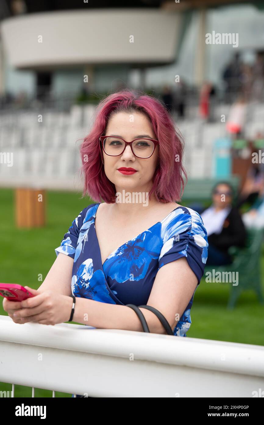 Ascot, Berkshire, UK. 13th July, 2024. A racegoer enjoying watching the ...