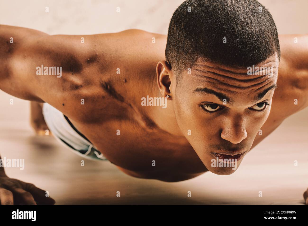 Man with a determined look, doing push-ups and showcasing a toned ...