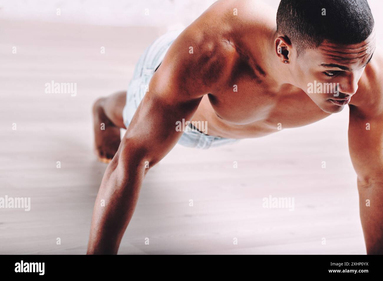Focused individual doing push-ups, with a muscular build and short hair ...