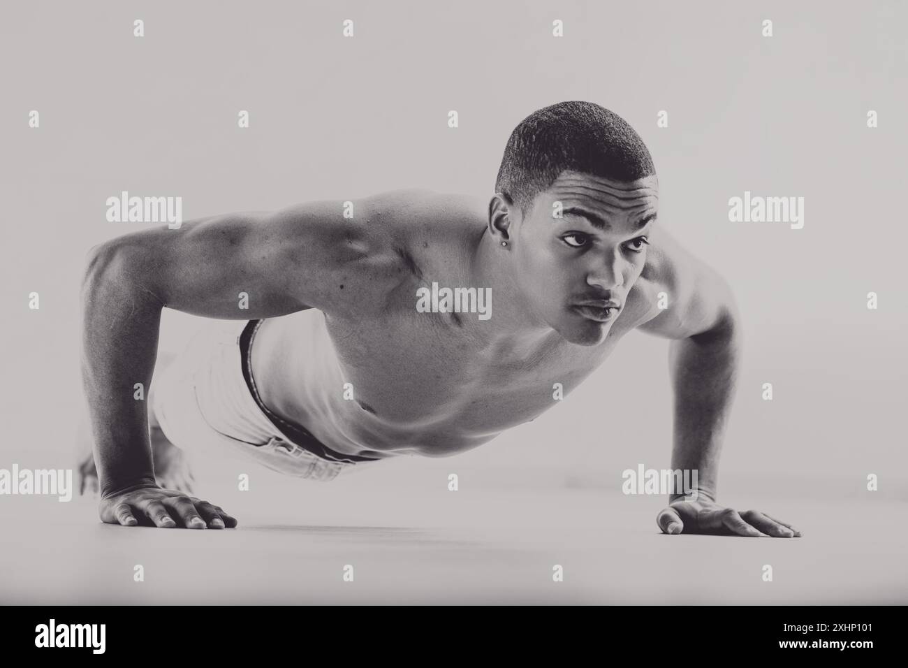 Black man in a 1950s style, performing a push-up with intense focus ...