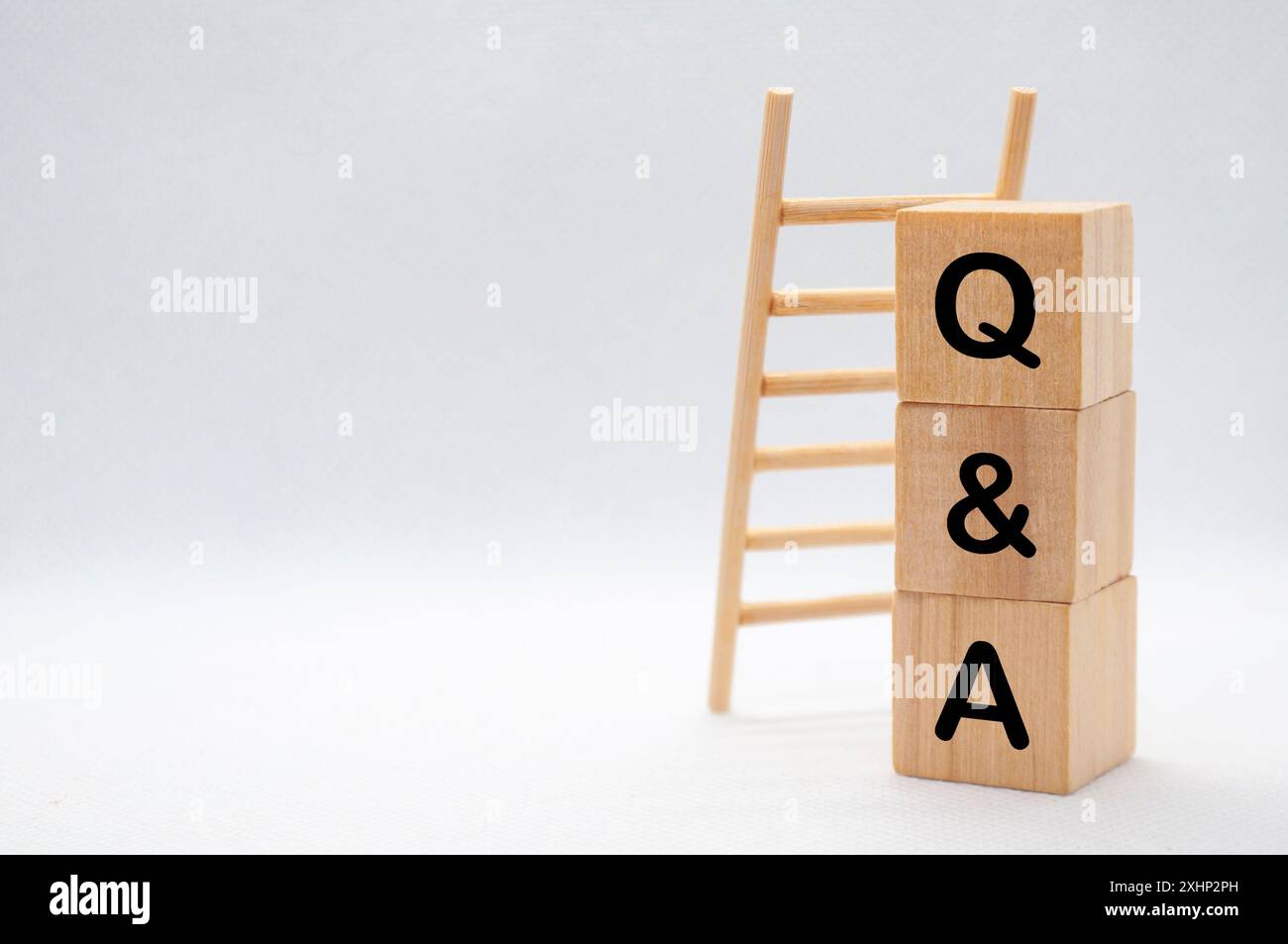 Question and Answer text on wooden cubes with wooden ladder background ...