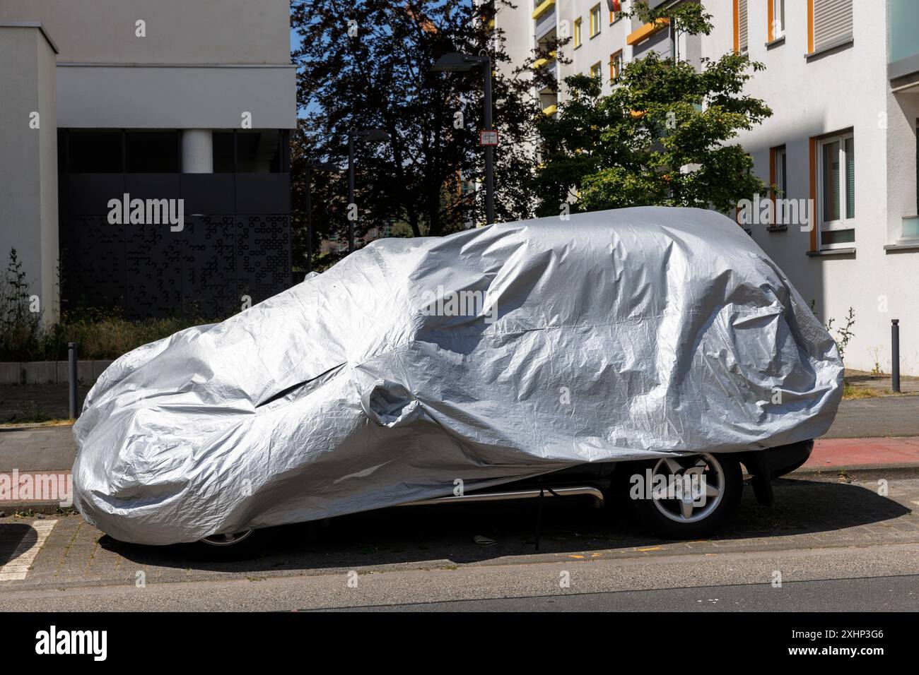 covered car parked on Bonner street, Cologne, Germany. abgedecktes Auto ...