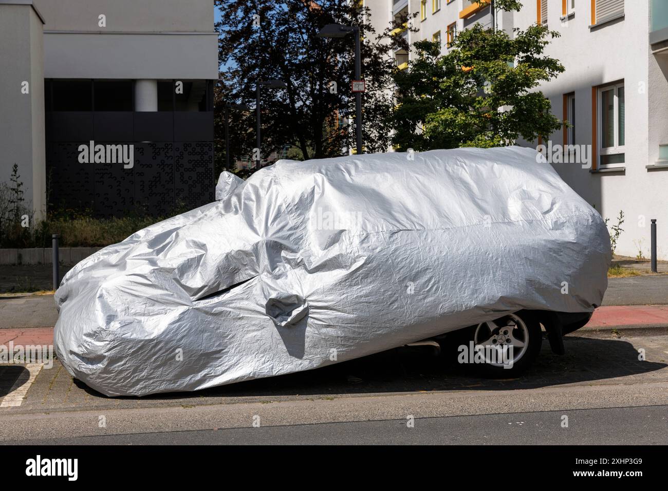 covered car parked on Bonner street, Cologne, Germany. abgedecktes Auto ...