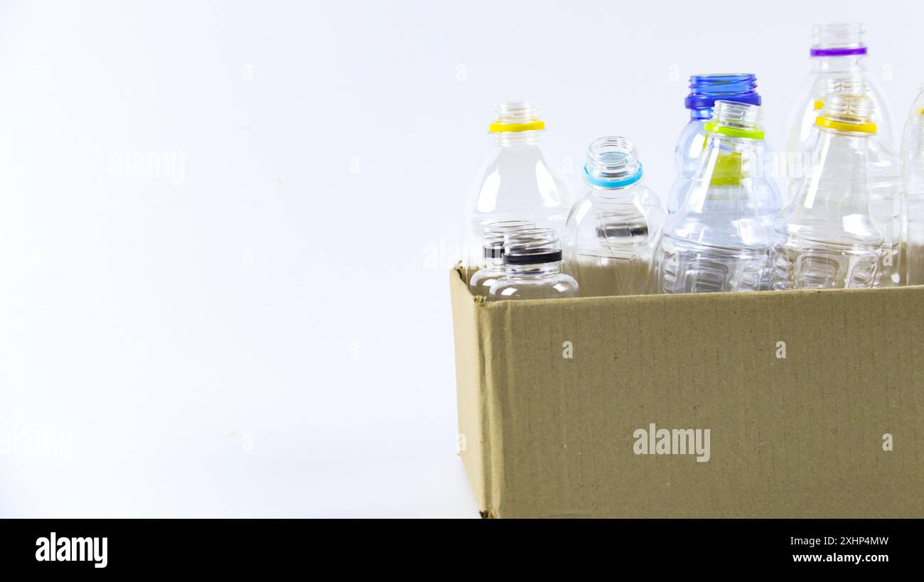 Clear plastic bottles on a white surface, awaiting recycling ...