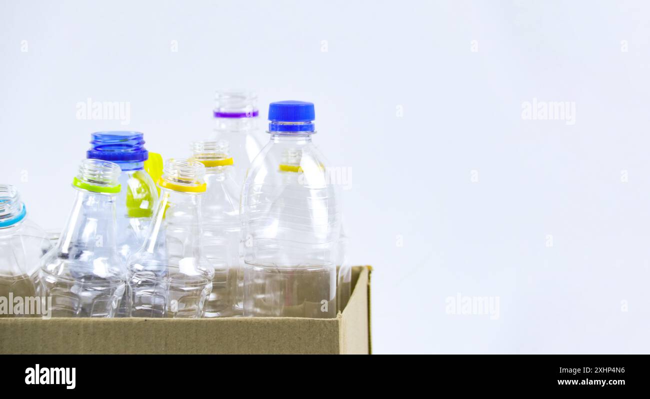 Clear plastic bottles on a white surface, awaiting recycling ...