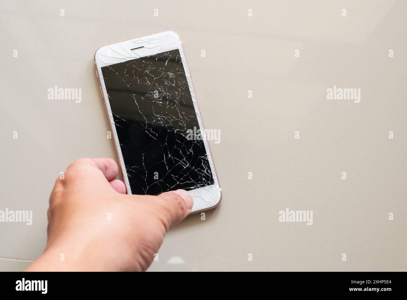 Hand holding mobile phone with broken glass screen Stock Photo - Alamy
