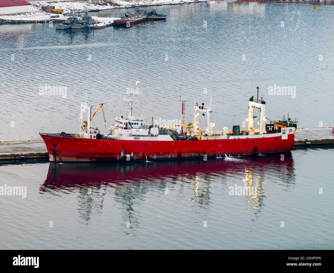 A large red ship is docked at a pier of the port of Ushuaia Stock Photo ...