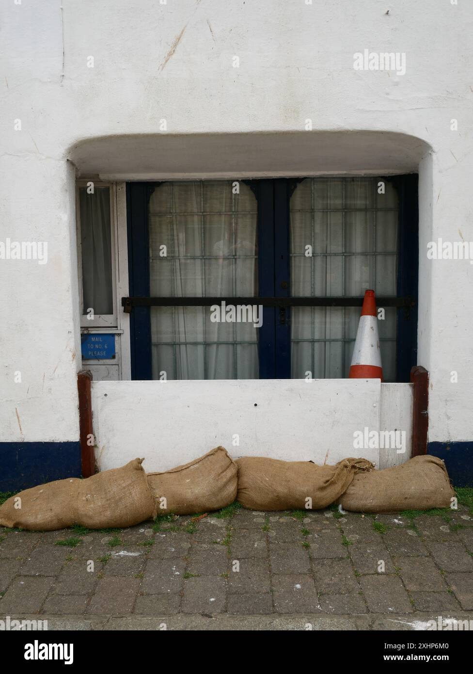 Flood defence barrier and sandbags in place on a property in Salcombe Devon in an effort to ...