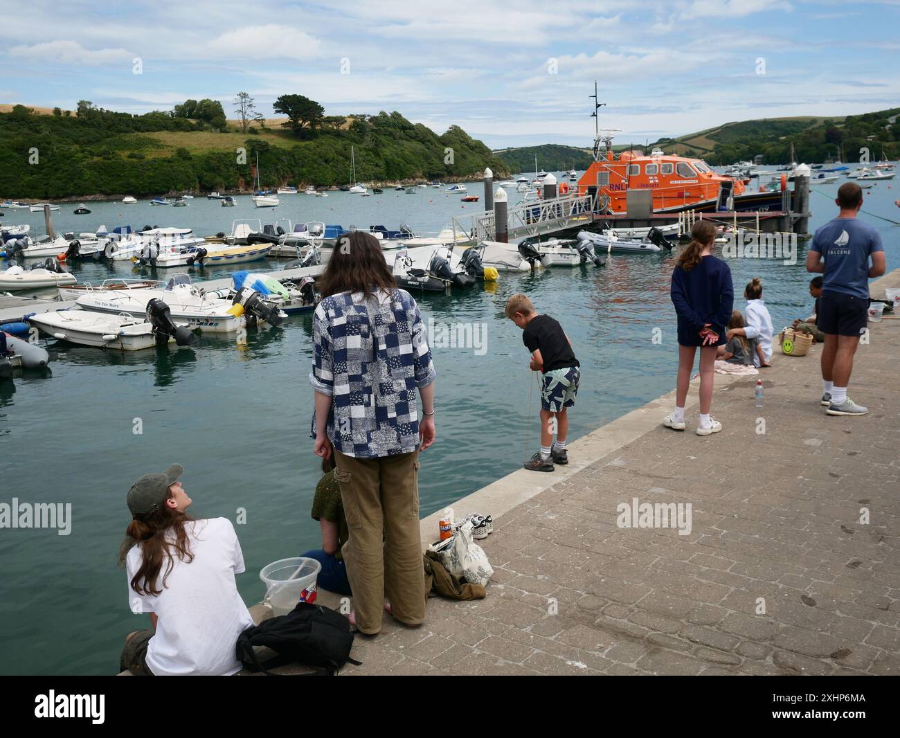 Family fun people enjoy crabbing off jetty in Salcombe, South Hams ...