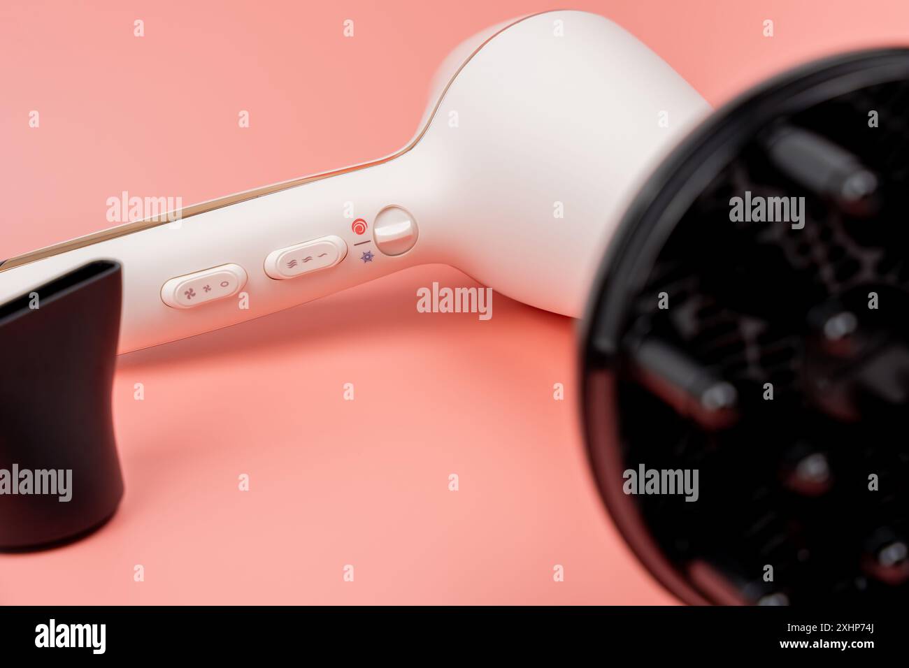 Hair dryer for drying hair on a pink background. The buttons are ...
