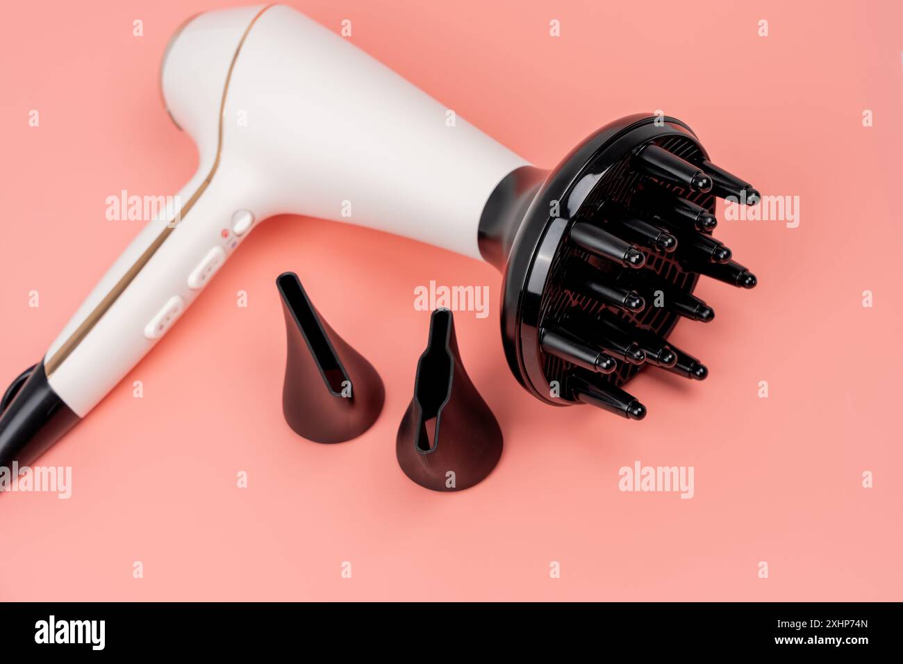 Hair dryer for drying hair on a pink background. The buttons are ...