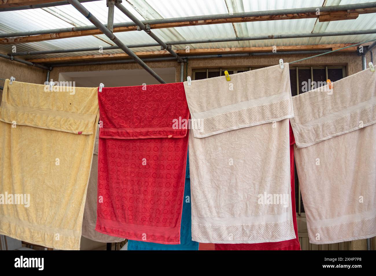Colorful towels hang on a wire, drying in the breeze after being ...