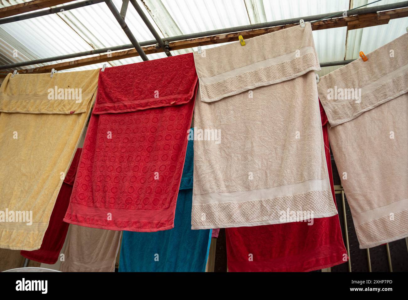Colorful towels hang on a wire, drying in the breeze after being ...