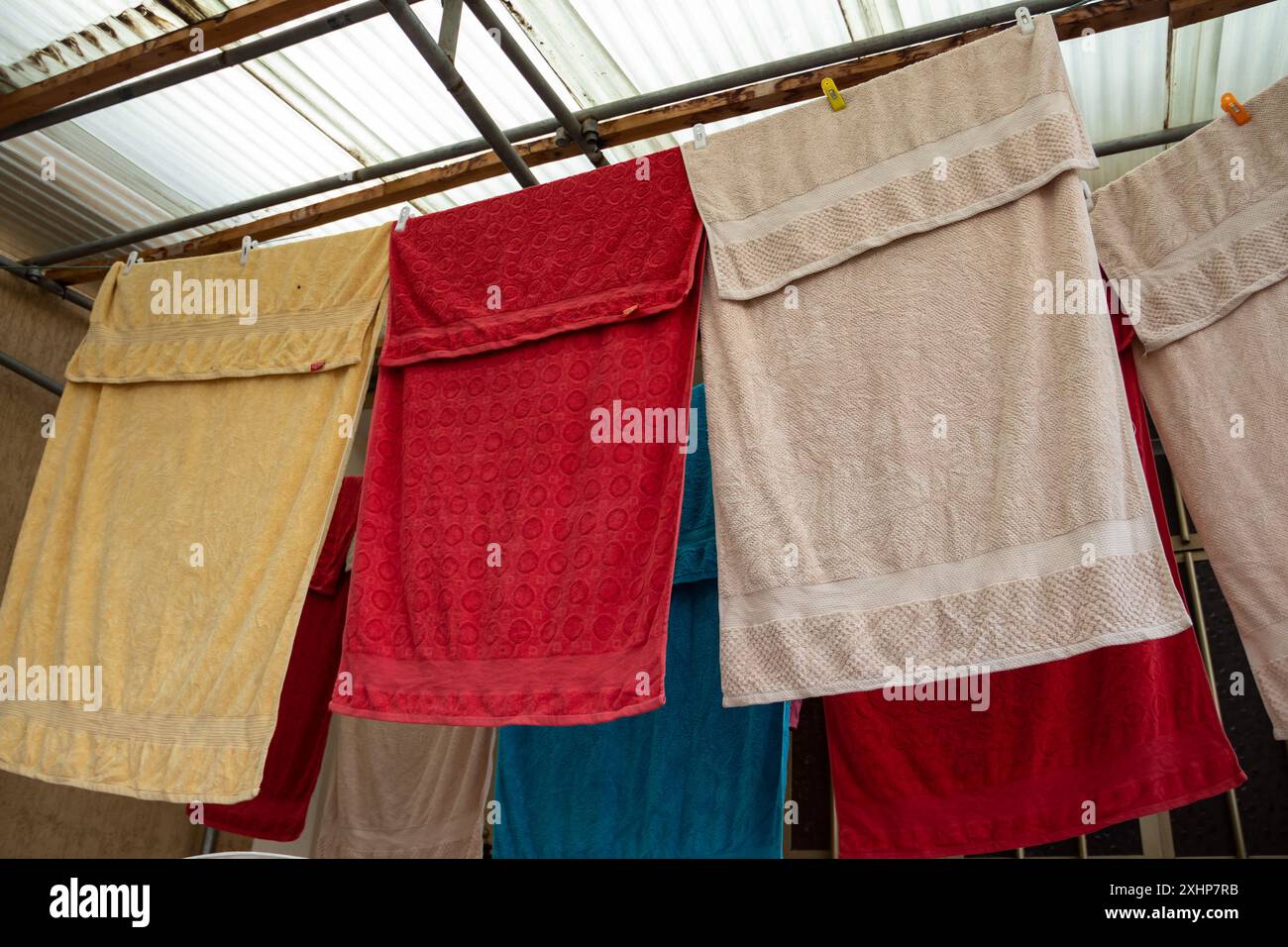 Colorful towels hang on a wire, drying in the breeze after being ...