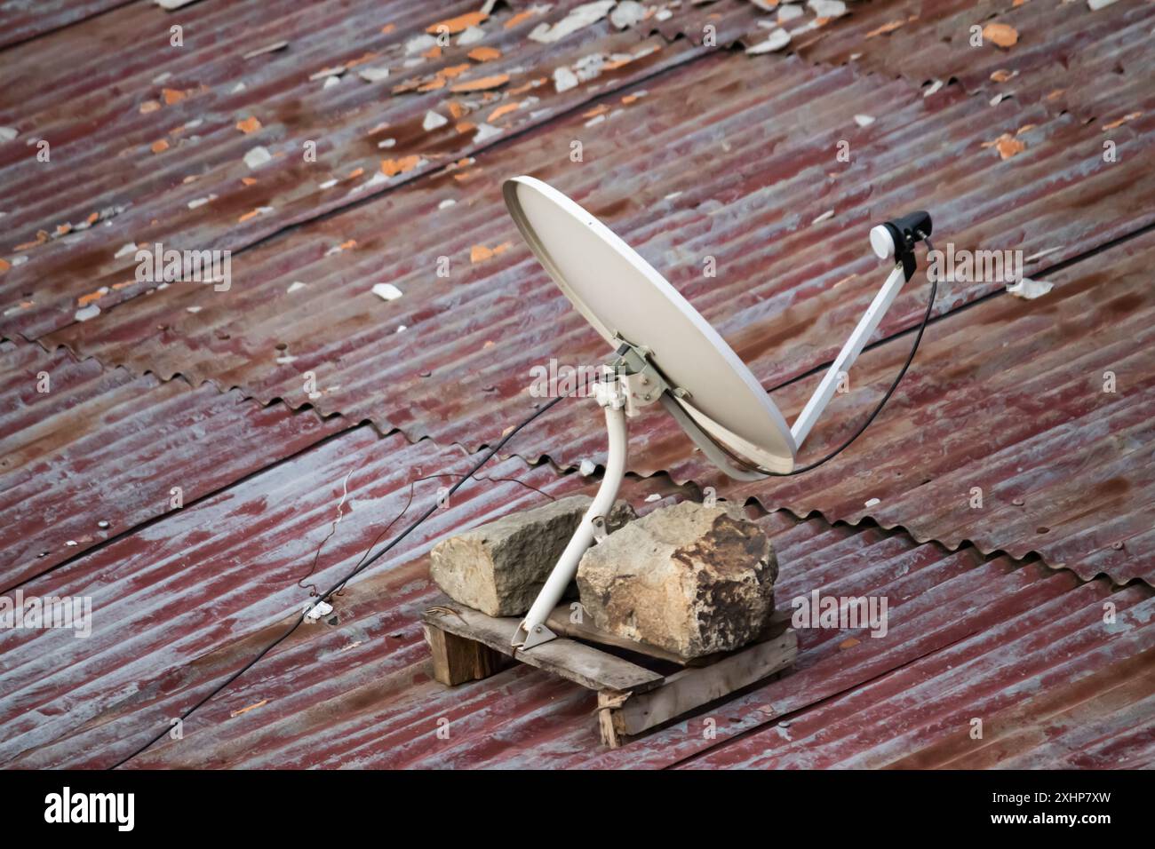 Old, rusty satellite dishes adorn the roofs of a settlement, reflecting ...
