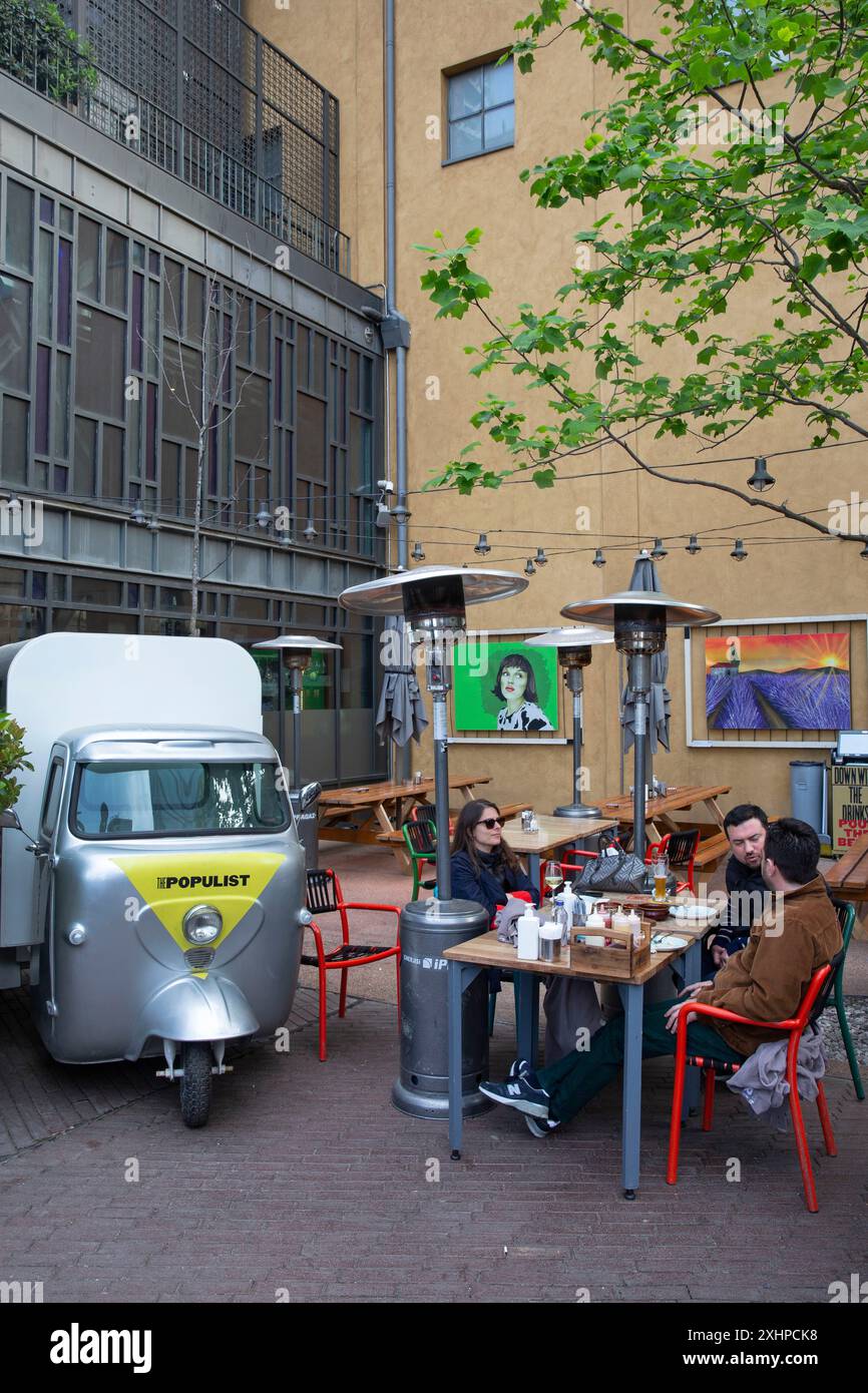 Turkey, Istanbul, Bomontiada, young people sitting at a cafe terrace in ...