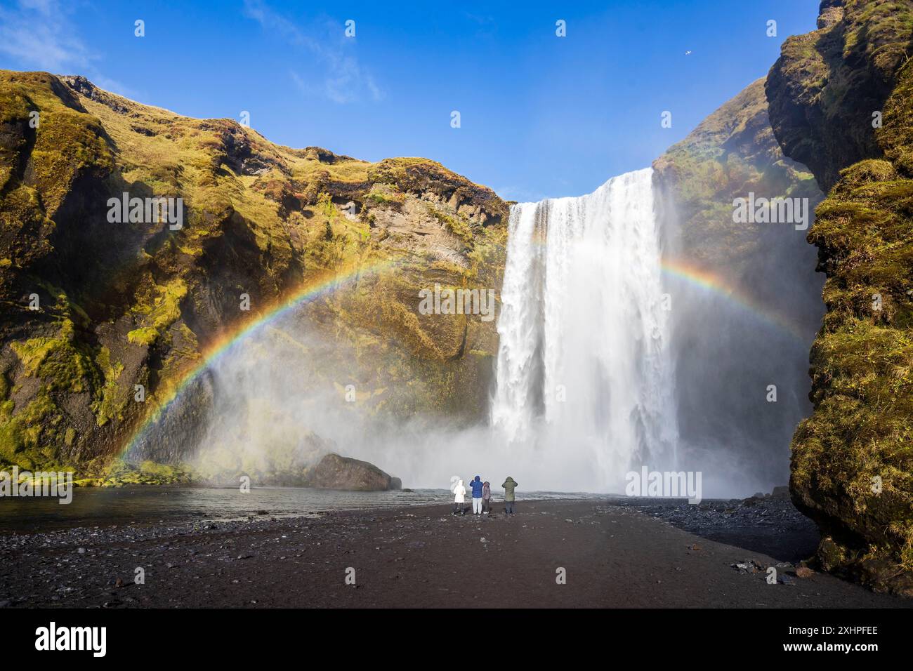 Iceland, Sudurland region, Skógar, figures contemplate a rainbow in ...