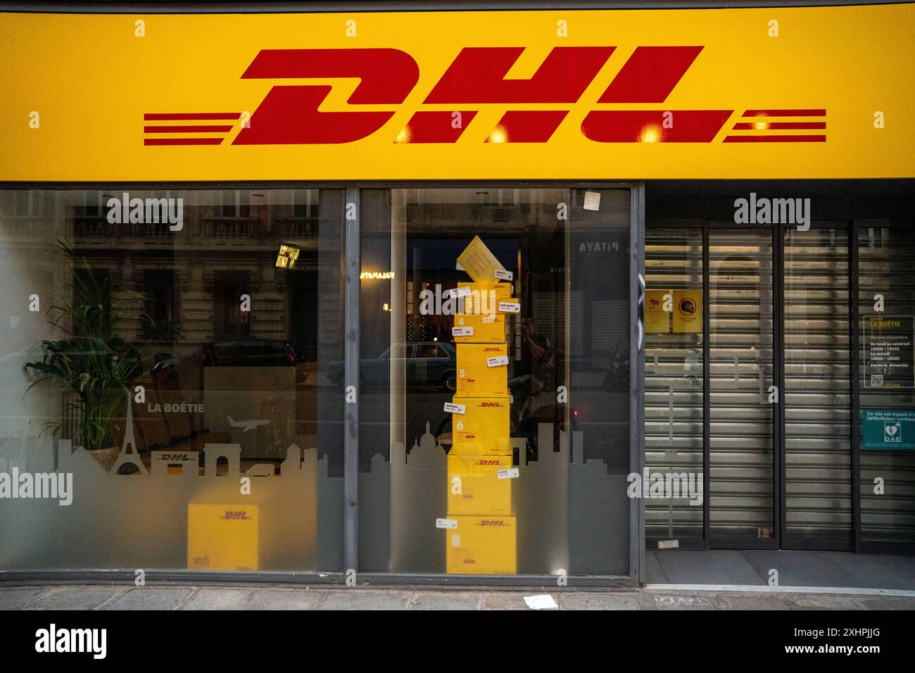 Paris, France - July 14, 2024: A DHL store in Paris, closed at night ...