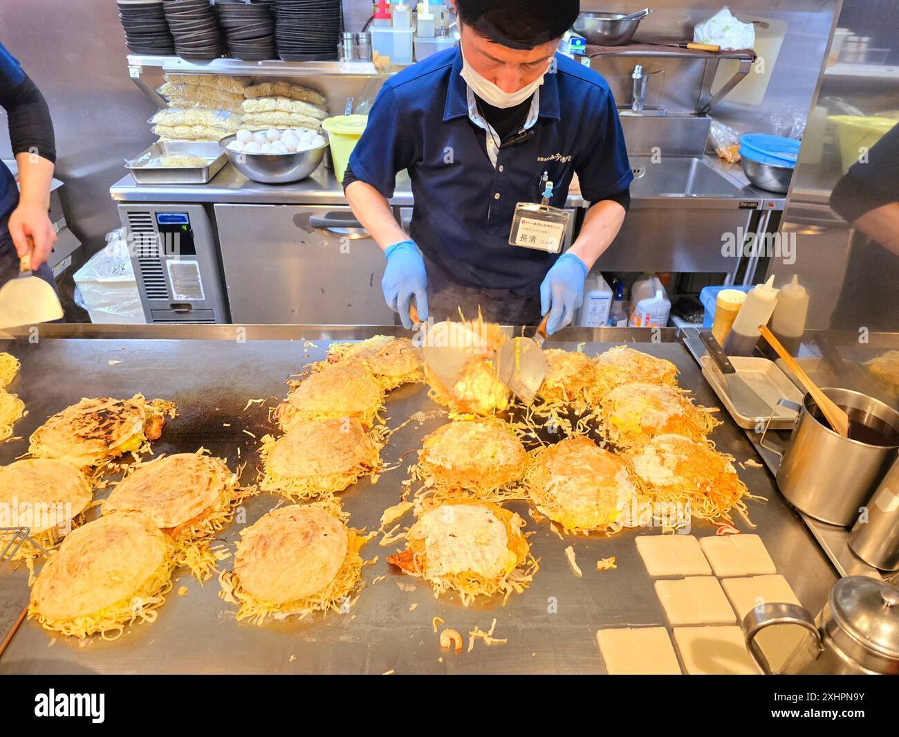 Chefs preparing Okonomiyaki, known as Hiroshima’s soul food and served ...