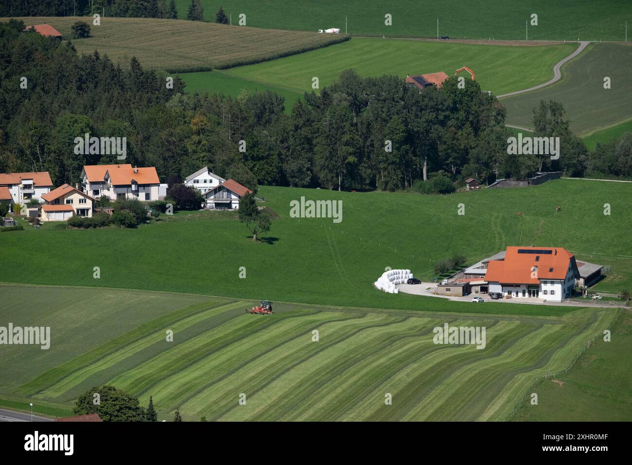 A rural landscape with a farmhouse and a few other houses. The ...